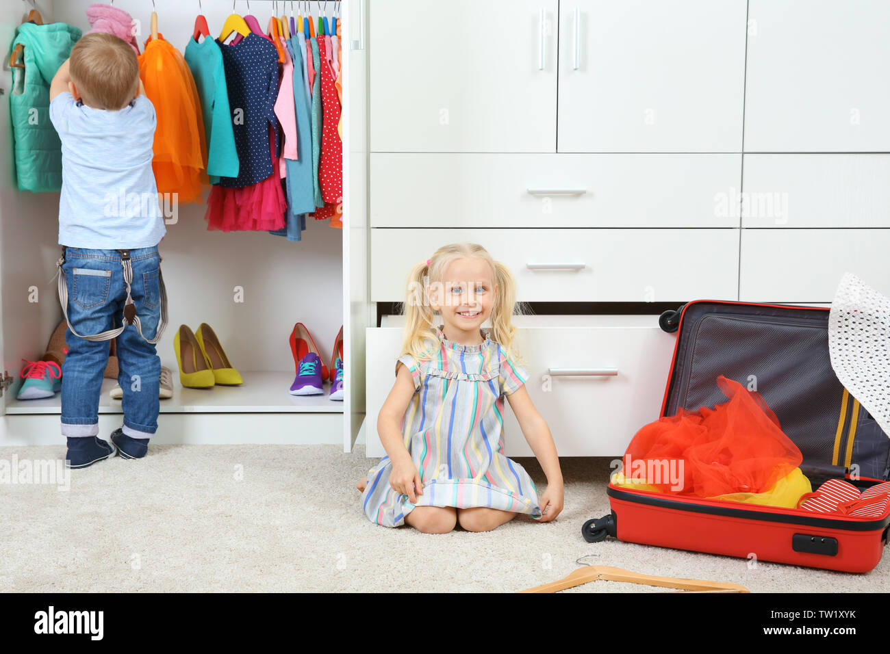 Cute small kids playing in wardrobe Stock Photo - Alamy