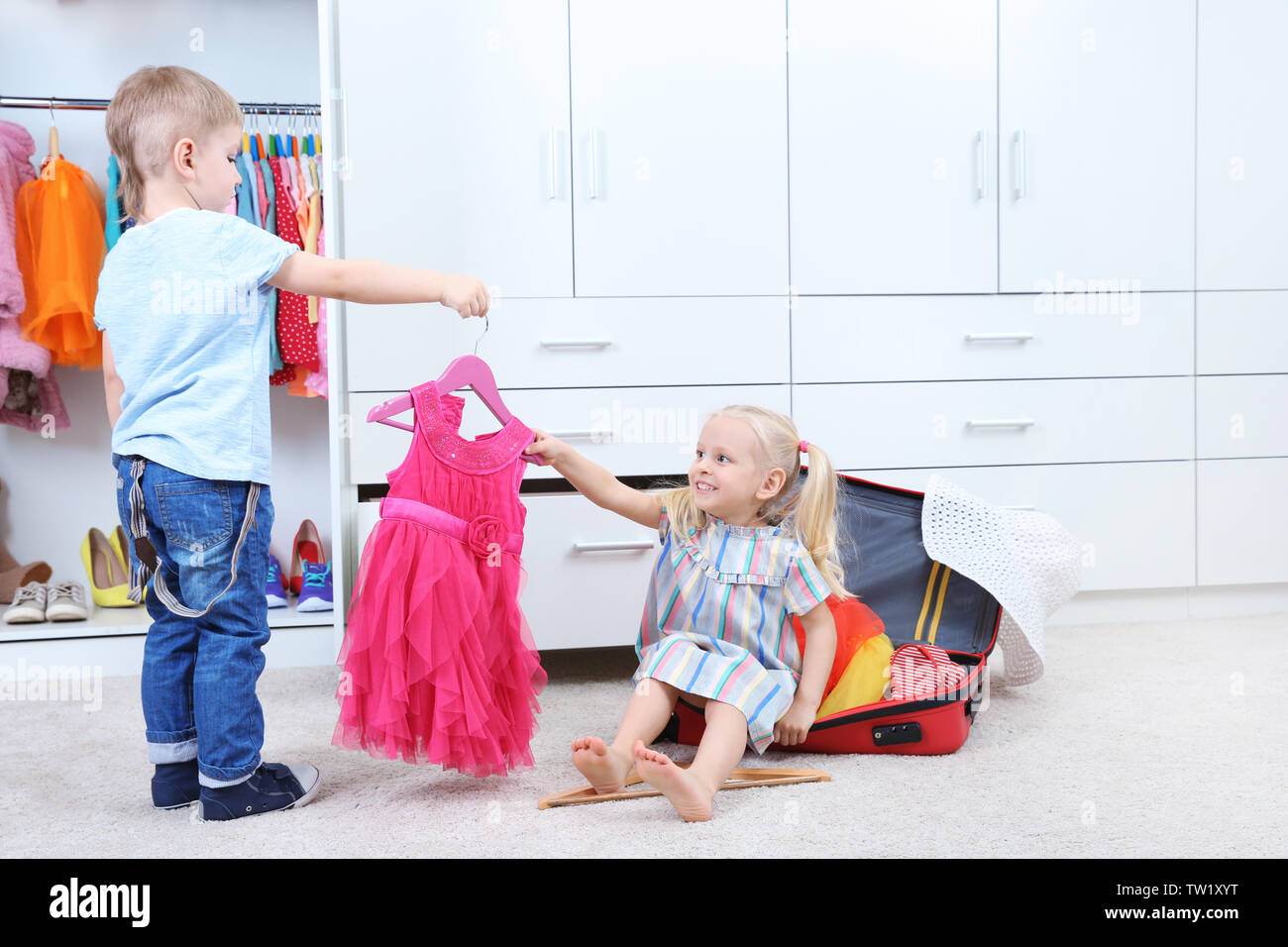 Cute small kids playing in wardrobe Stock Photo - Alamy