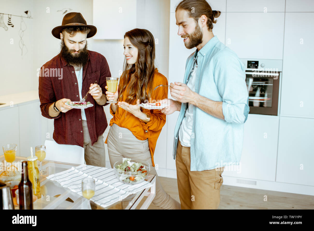 Young friends talking and having fun during the lunch, standing ...