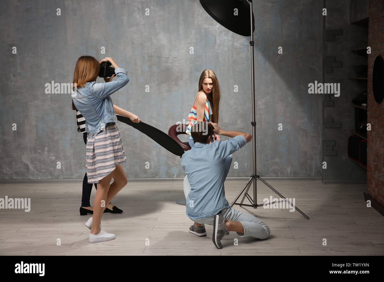 Group of students taking photo of model during photography classes ...