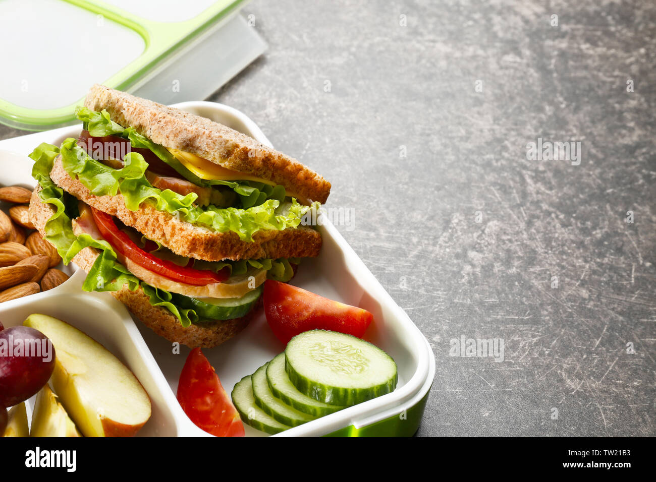 Lunch box with delicious food on grunge background Stock Photo - Alamy
