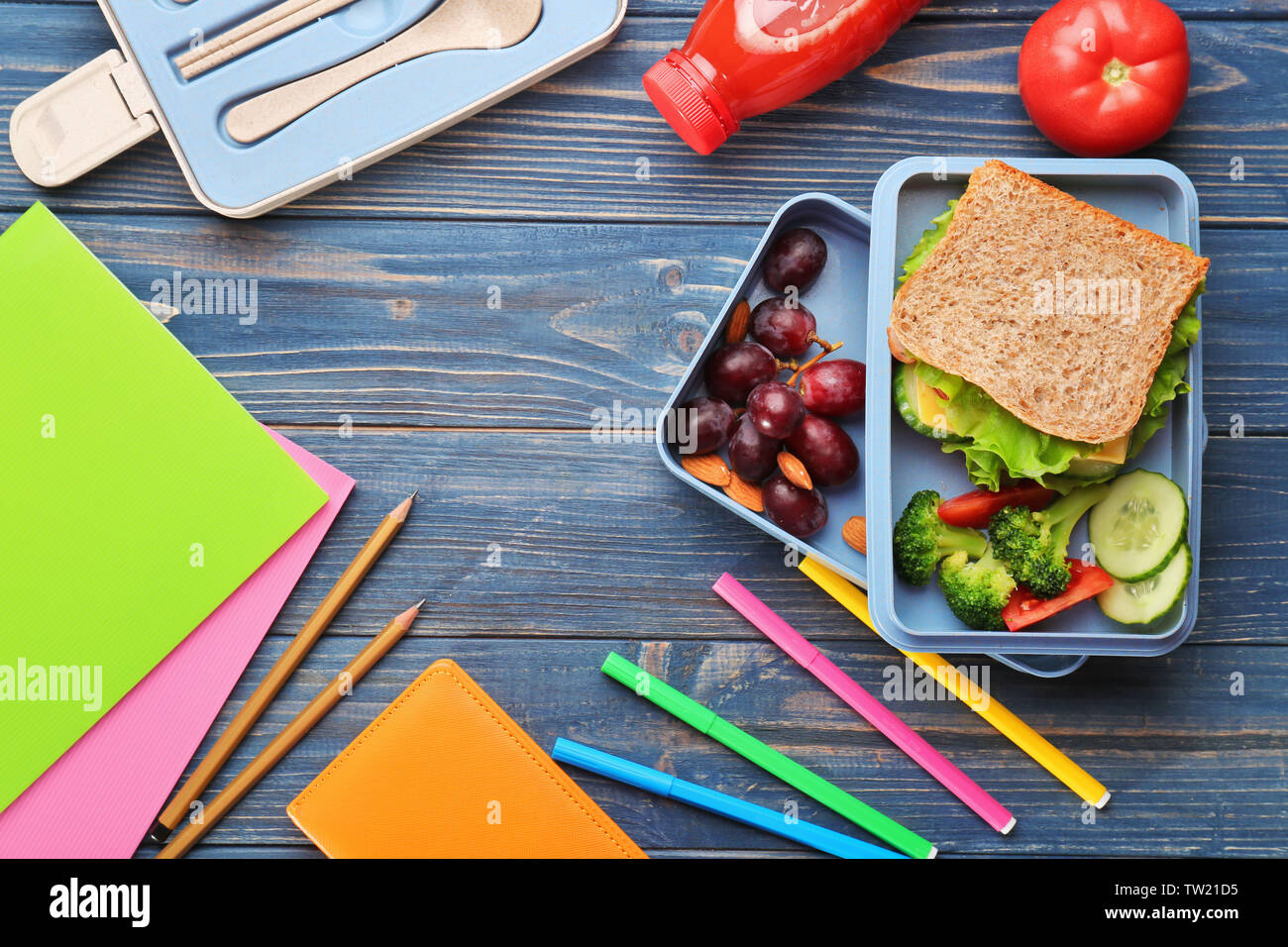 Lunch box with delicious food and stationery on wooden background Stock ...