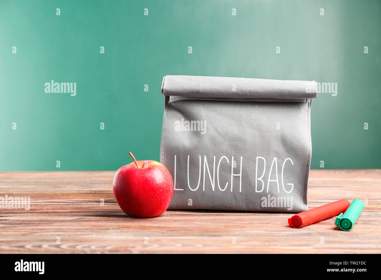 Lunch bag on wooden tabletop against chalkboard background Stock Photo ...