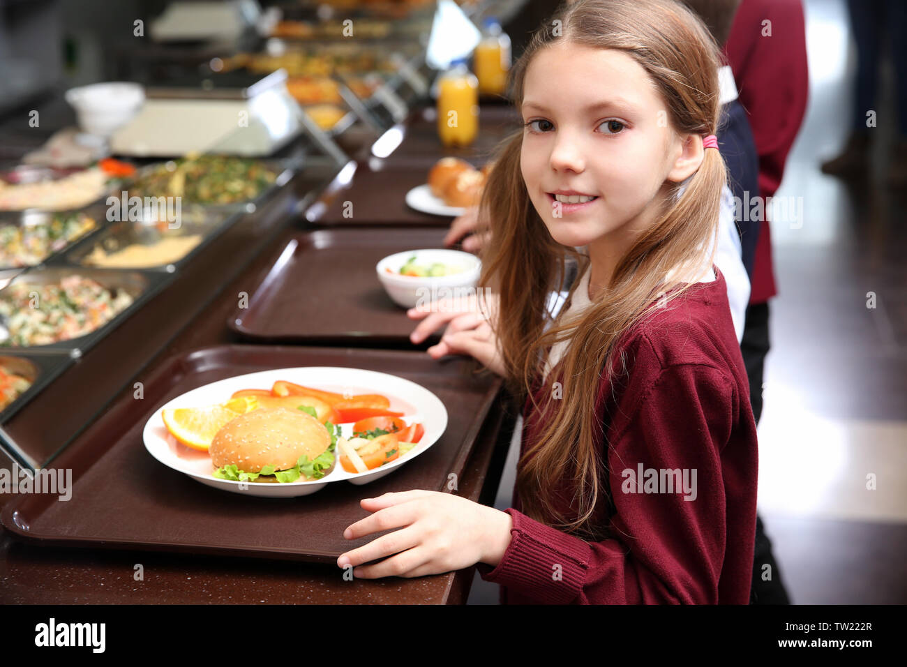 Beautiful little girl receiving food in school cafeteria Stock Photo ...