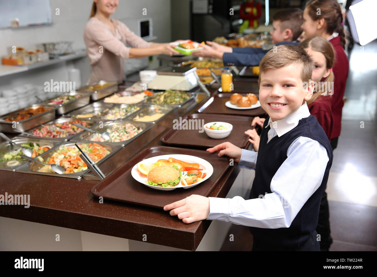 Cute little boy receiving food in school cafeteria Stock Photo - Alamy