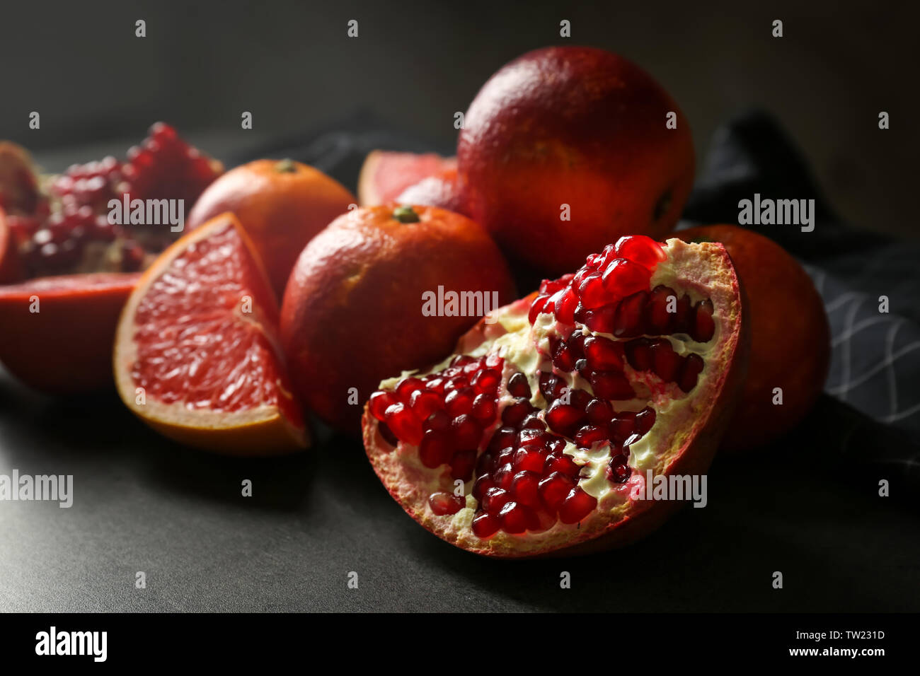 Heap of red citrus fruits and pomegranate on grunge background, closeup ...