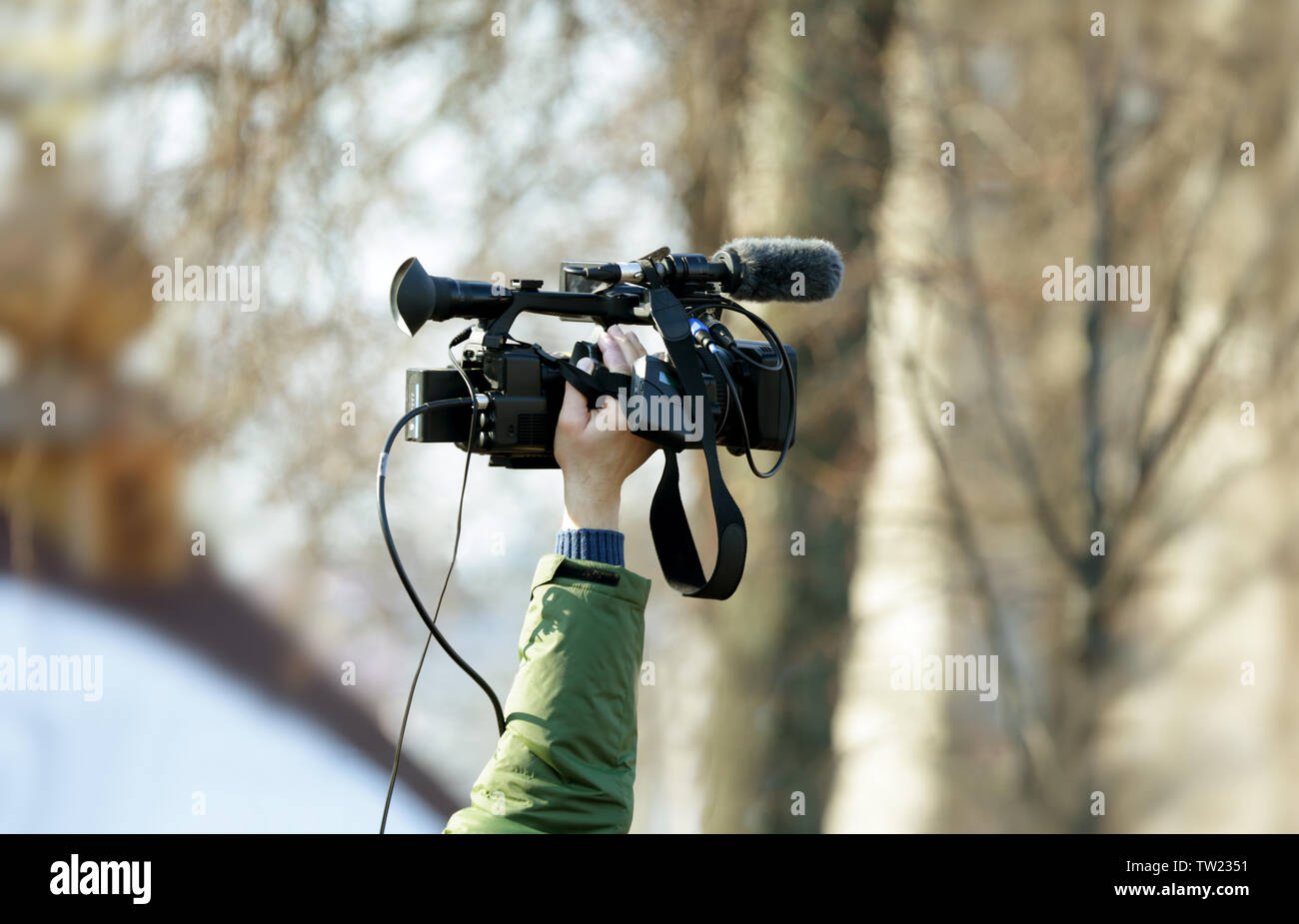 Professional camcorder in male hand outdoors Stock Photo - Alamy