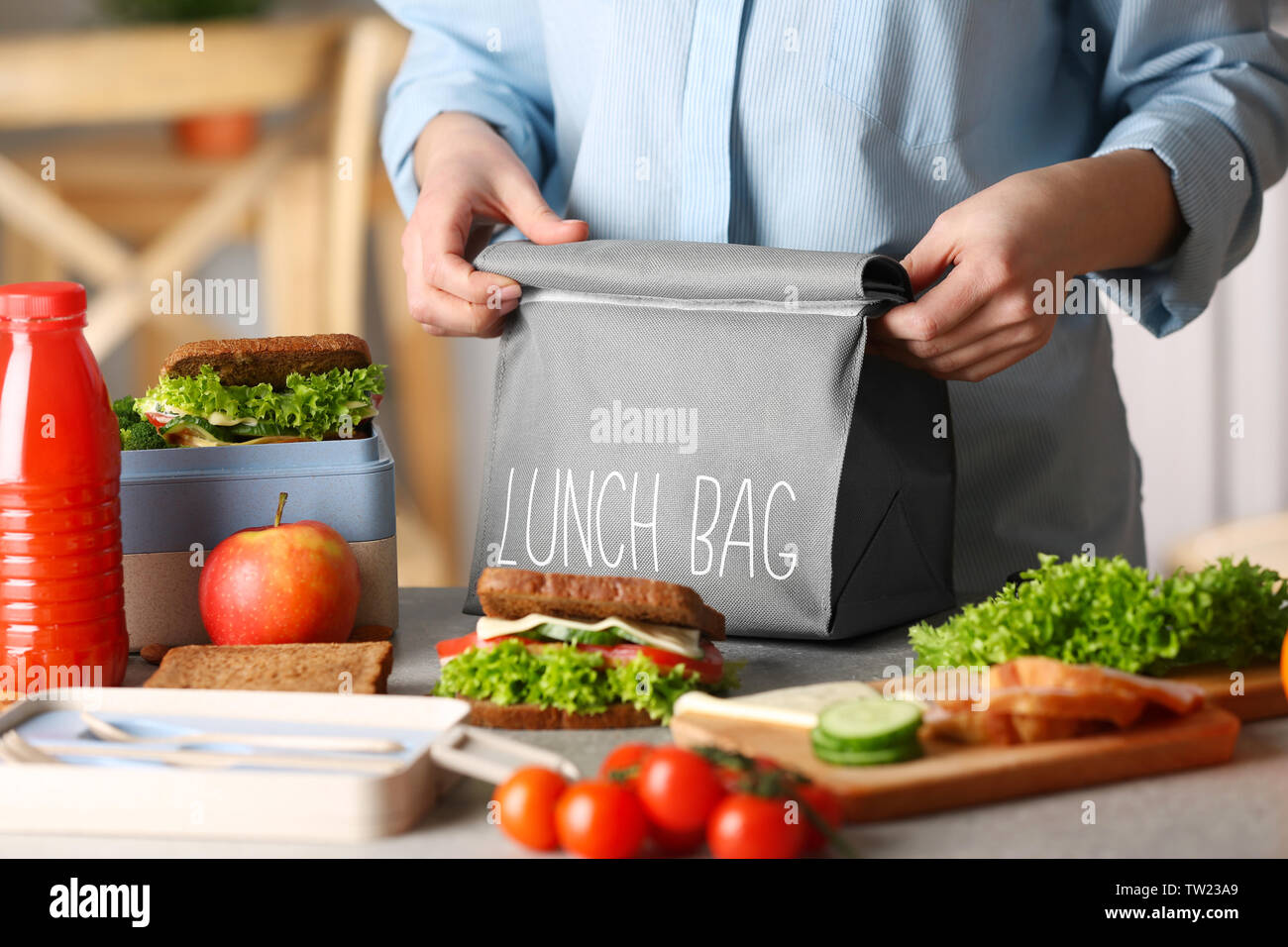 Mother packing meal for school lunch on table Stock Photo - Alamy