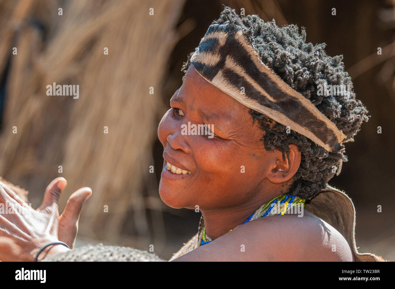 a San woman, also known as Bushmen, in joyous mood, clapping hands ...