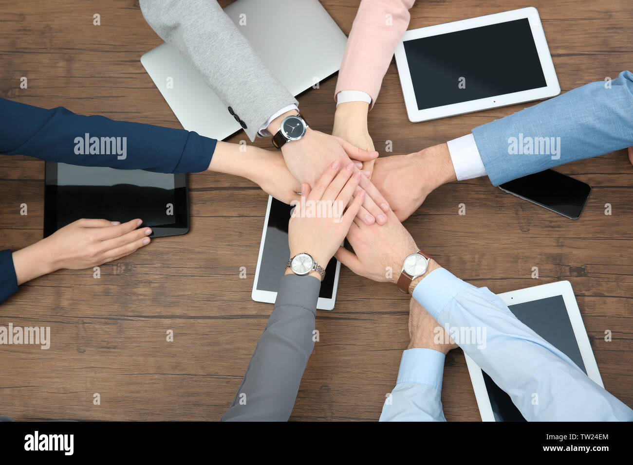 Team work concept. People sitting at table and holding hands together ...