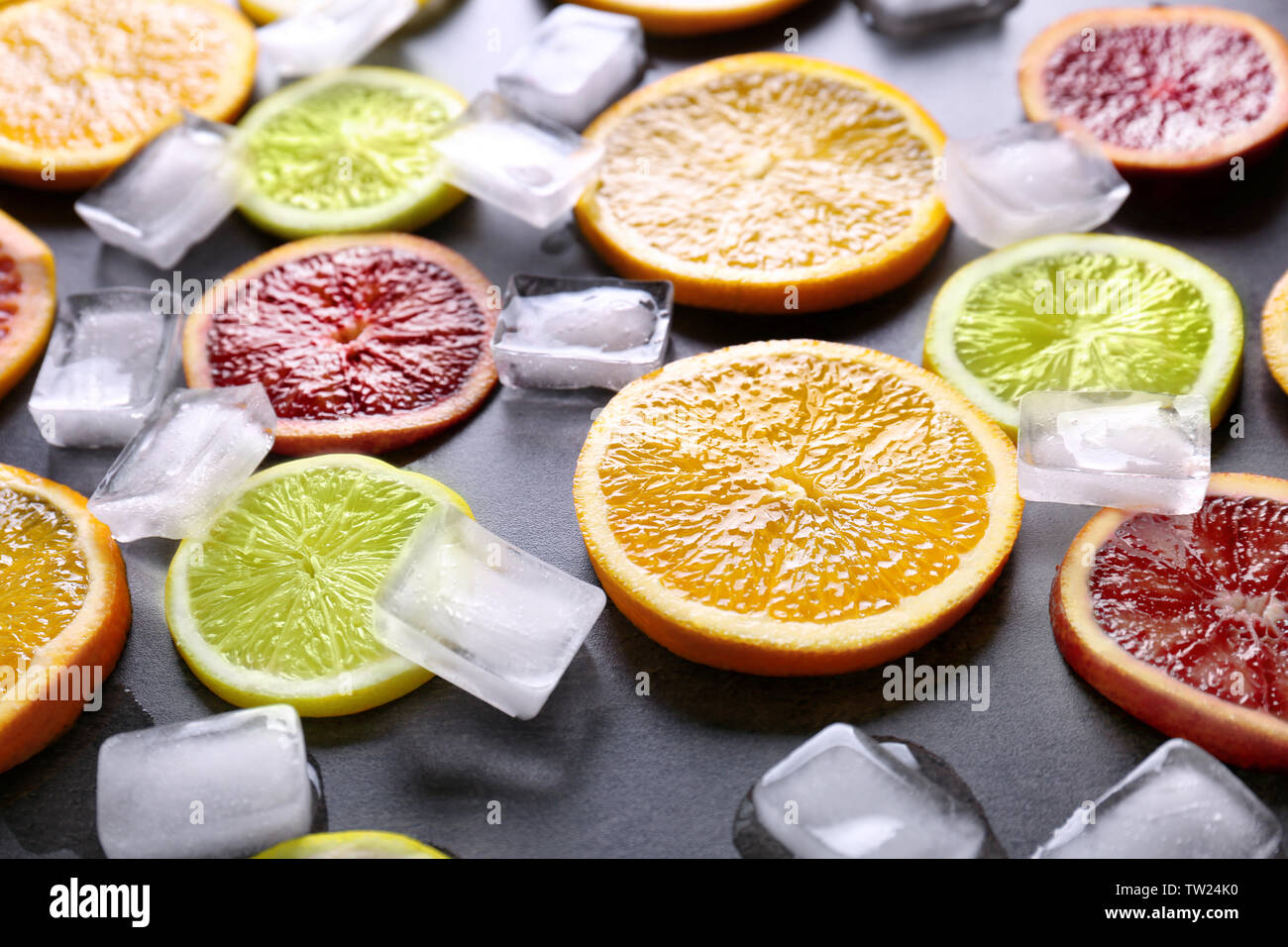 Juicy composition of citrus fruits and ice cubes on grunge background ...