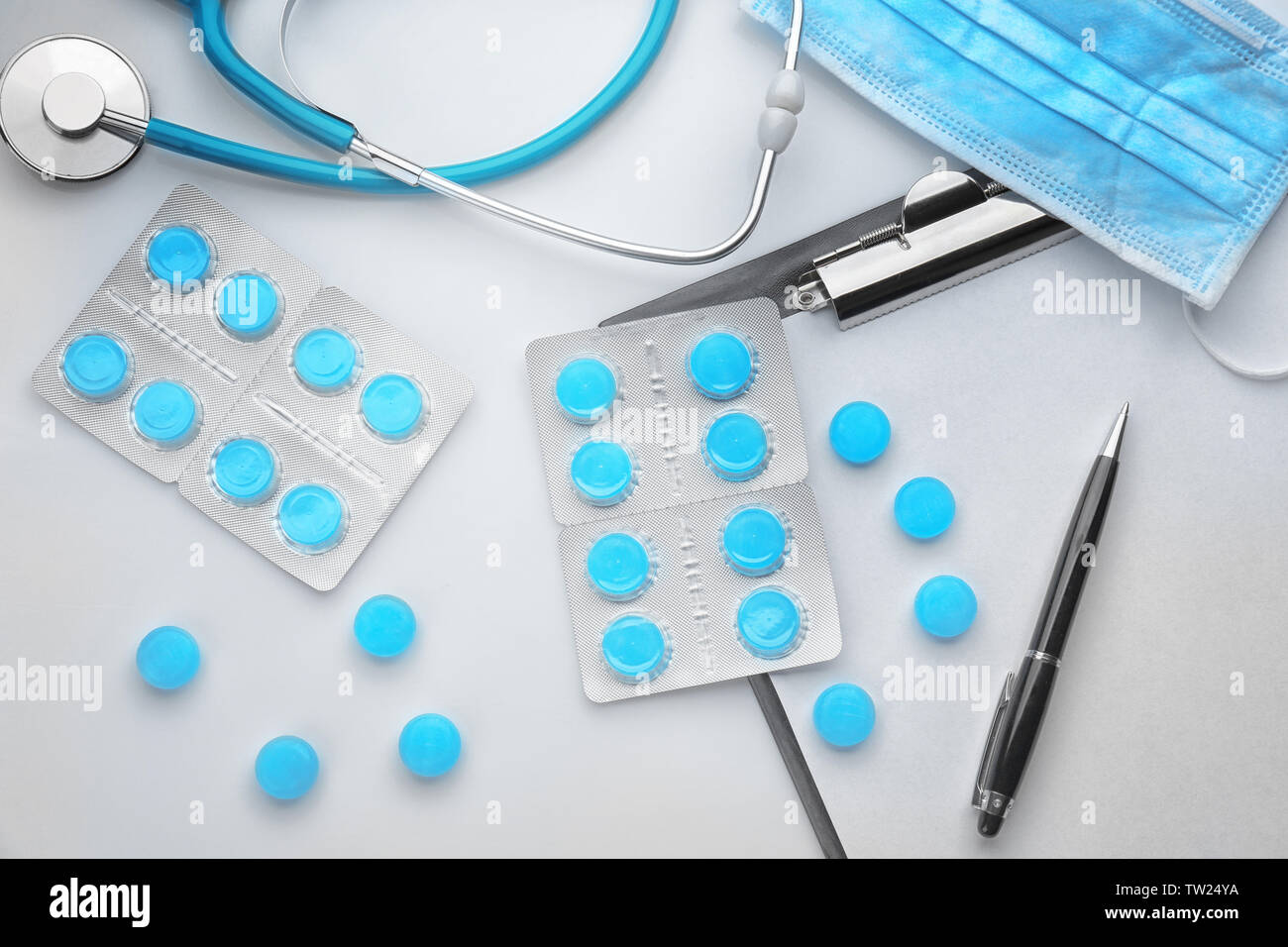 Cough drops, clipboard and medical equipment on white background Stock ...