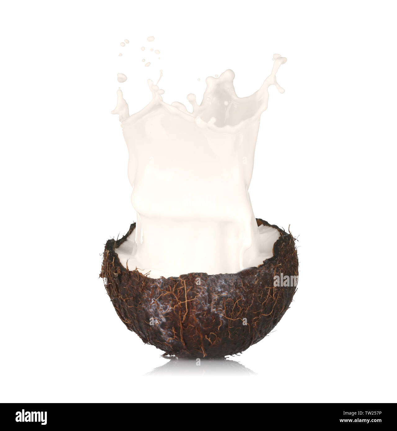 Cracked coconut with splashes of milk on white background Stock Photo ...