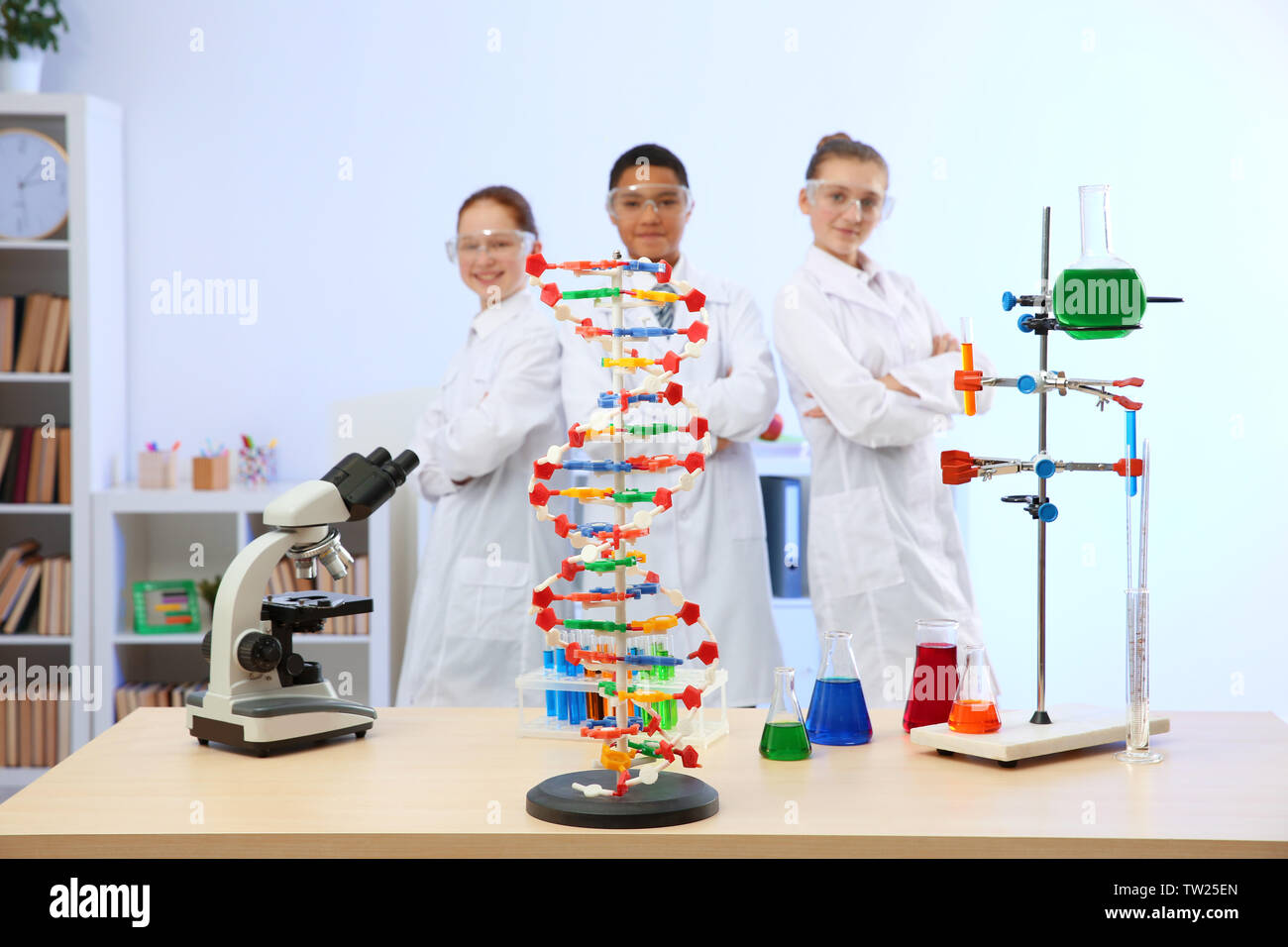 Workplace with DNA model and pupils standing in chemistry class Stock ...