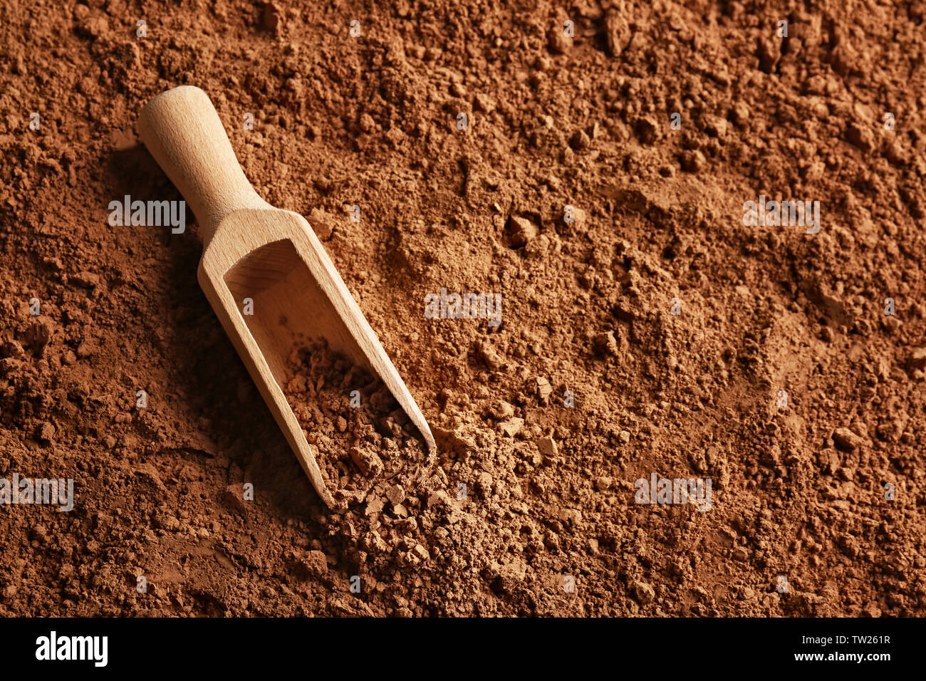 Wooden scoop on cocoa powder background Stock Photo - Alamy