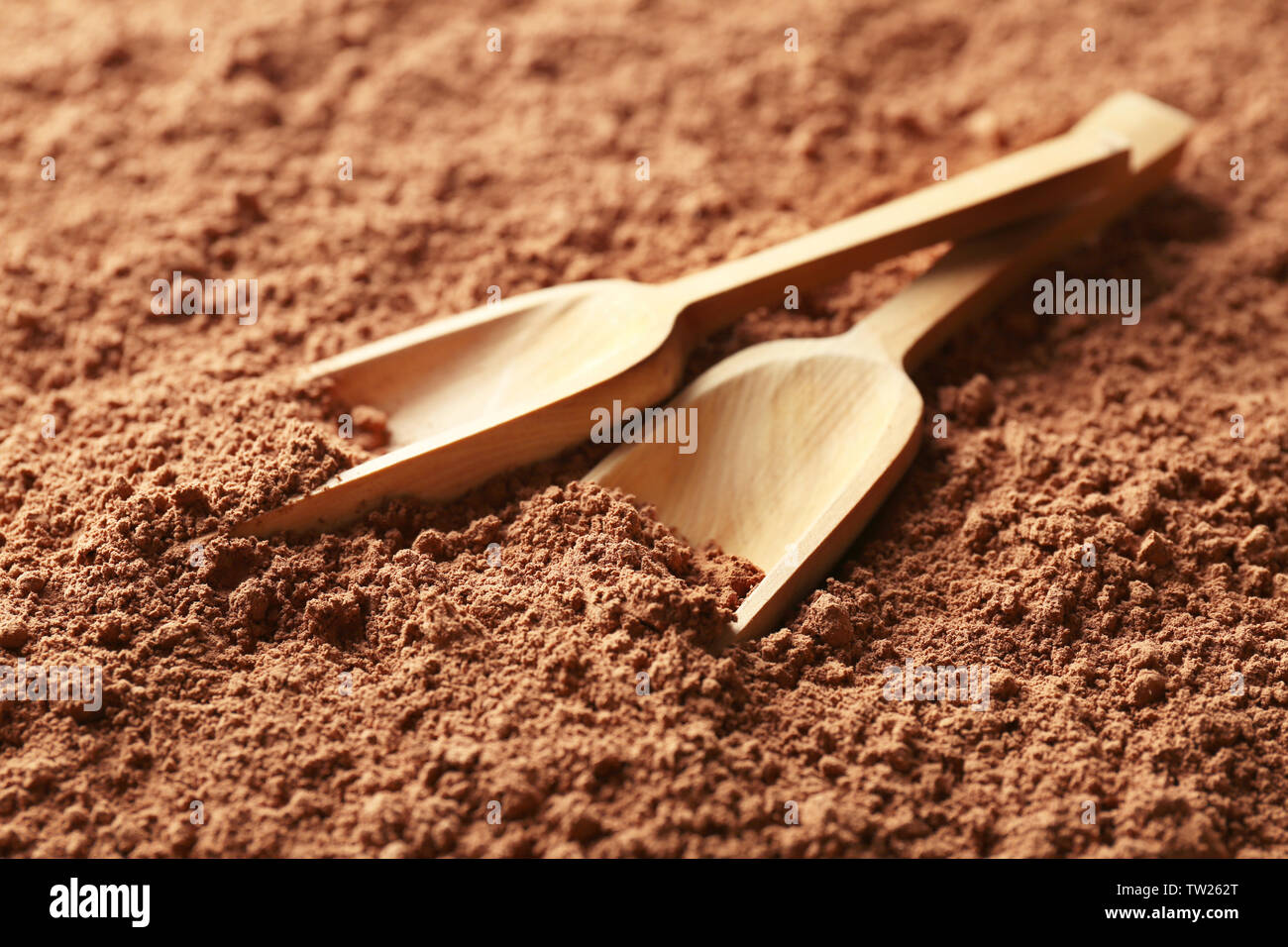 Wooden scoops on cocoa powder background Stock Photo - Alamy