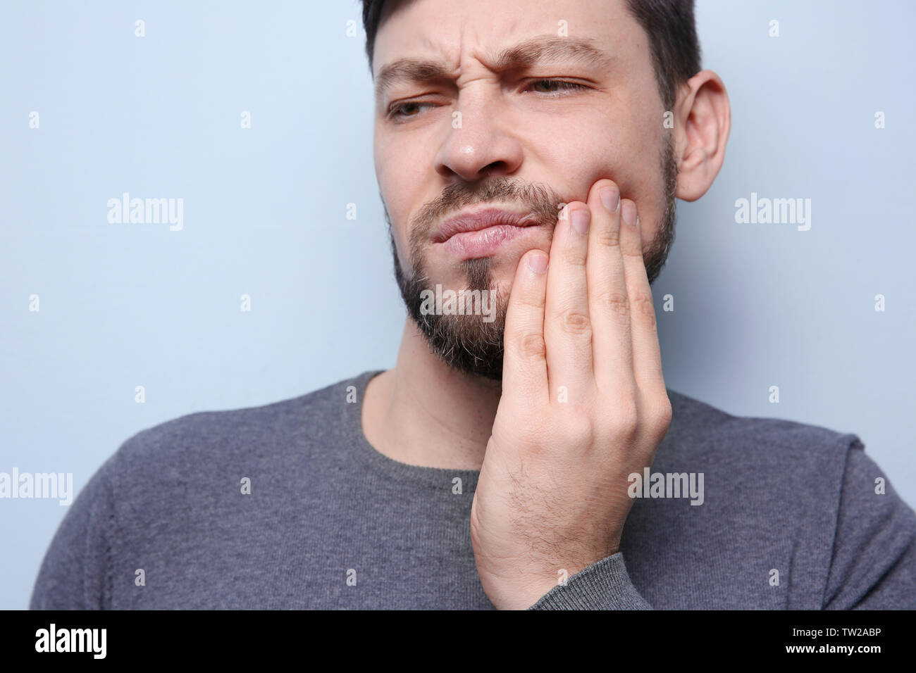 Handsome man suffering from toothache on color background Stock Photo ...