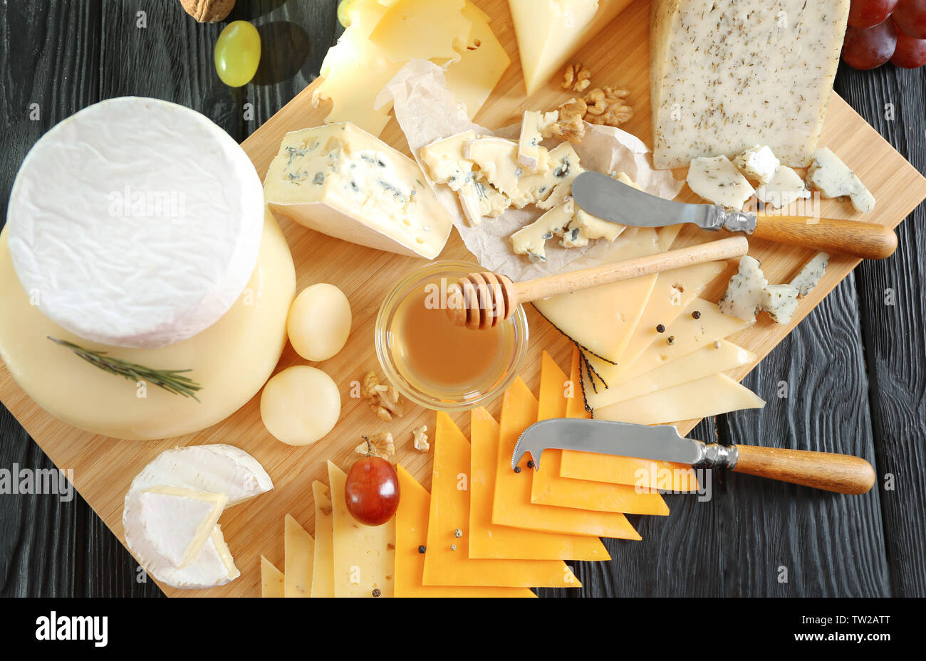 Wooden board with variety of cheese on table Stock Photo - Alamy