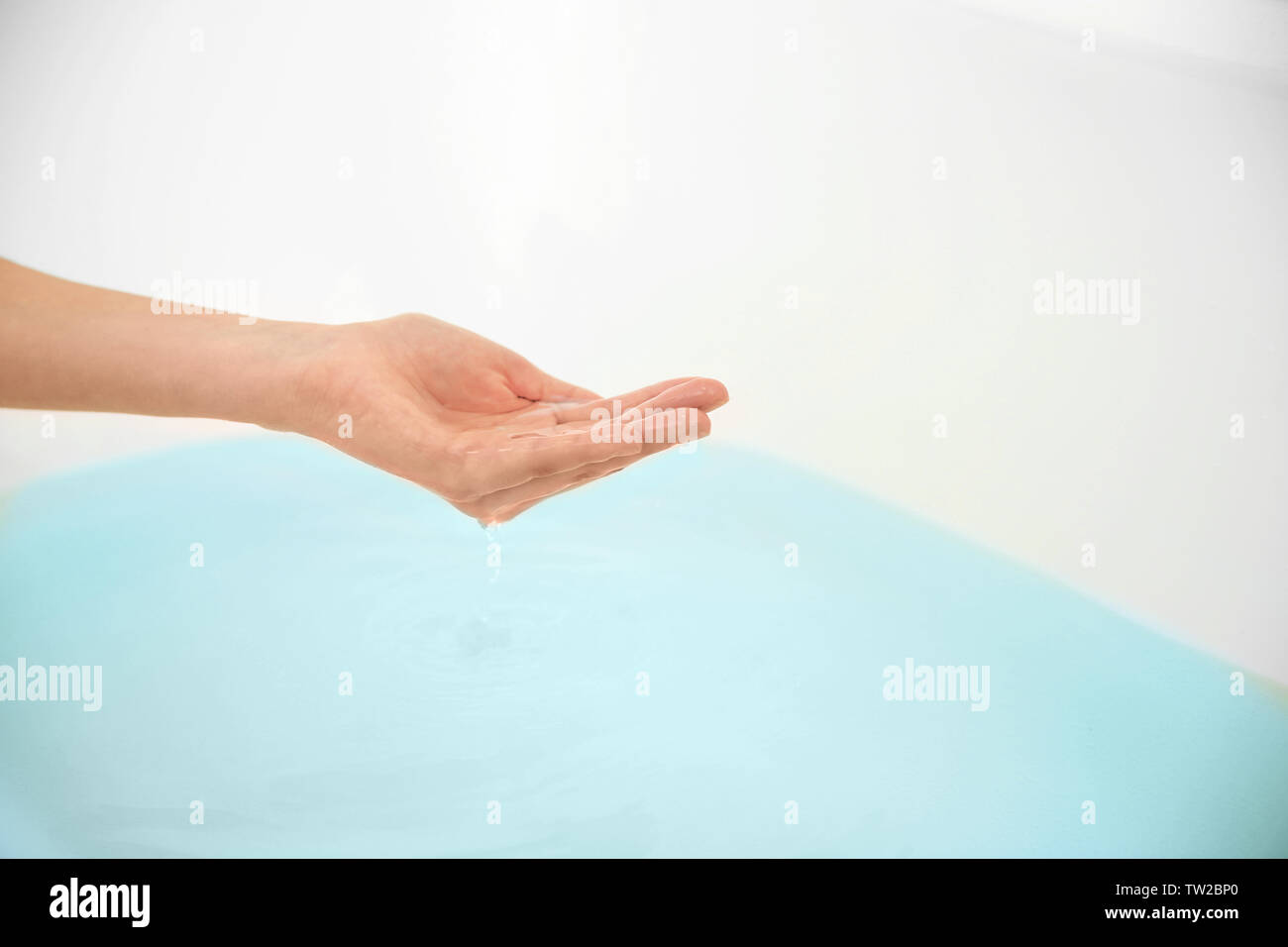 Female hand determining temperature of water in bathtub Stock Photo - Alamy
