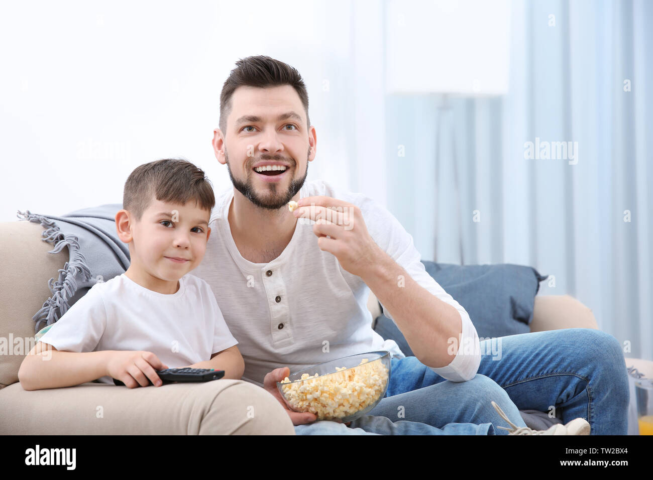 Father and son watching TV at home Stock Photo - Alamy