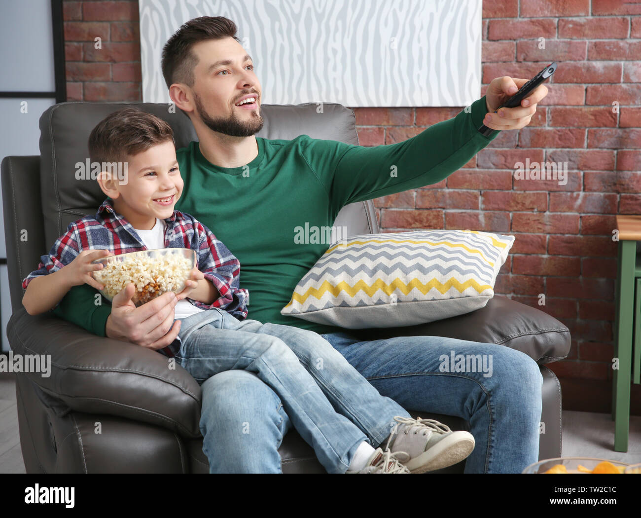 Father and son watching TV at home Stock Photo - Alamy