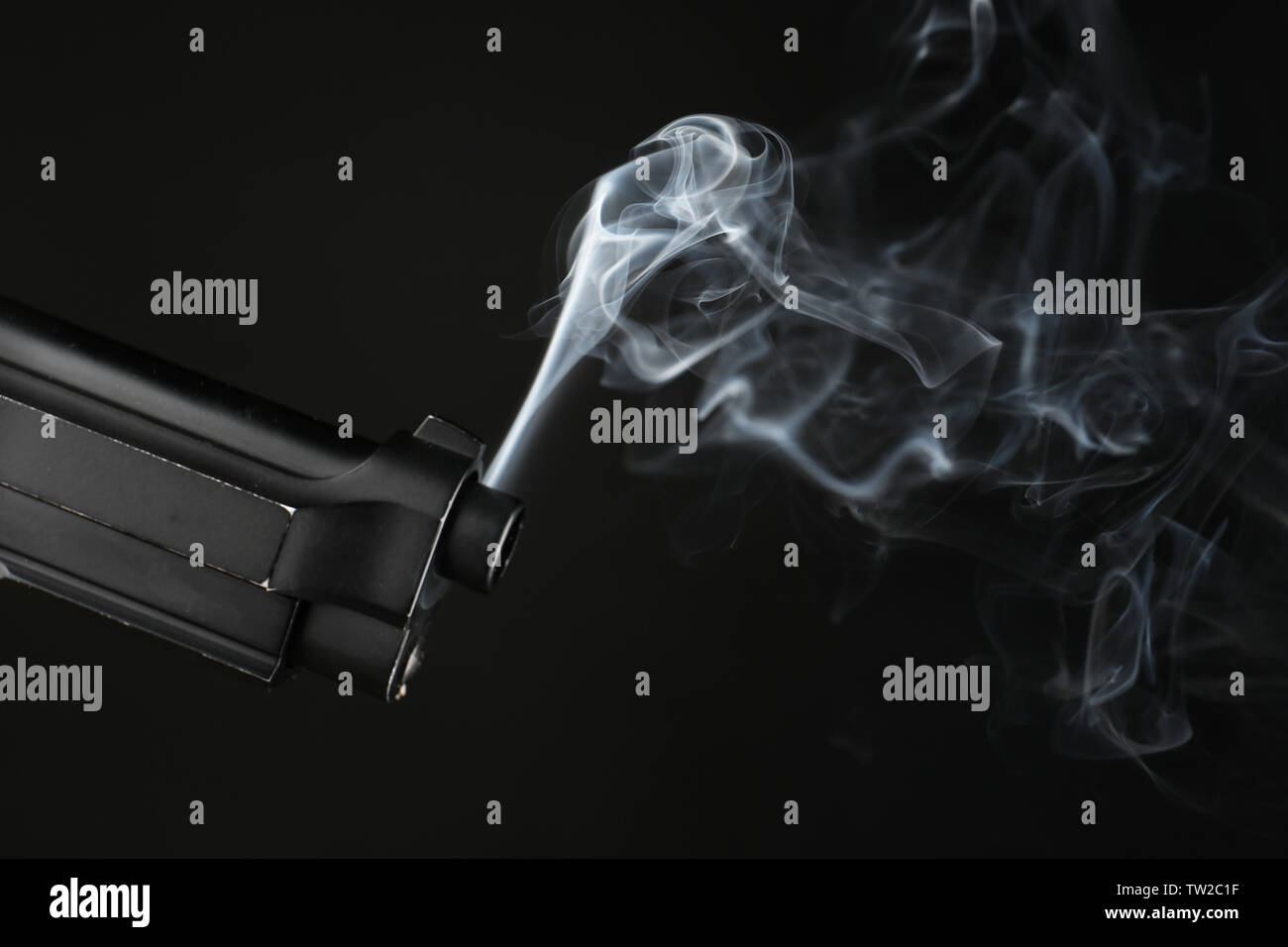 Smoking gun on black background Stock Photo - Alamy
