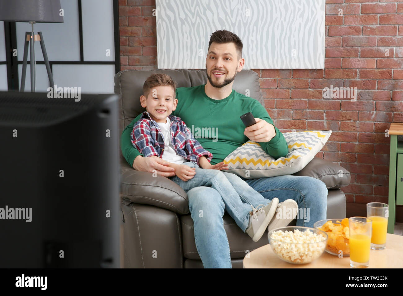Father and son watching TV at home Stock Photo - Alamy