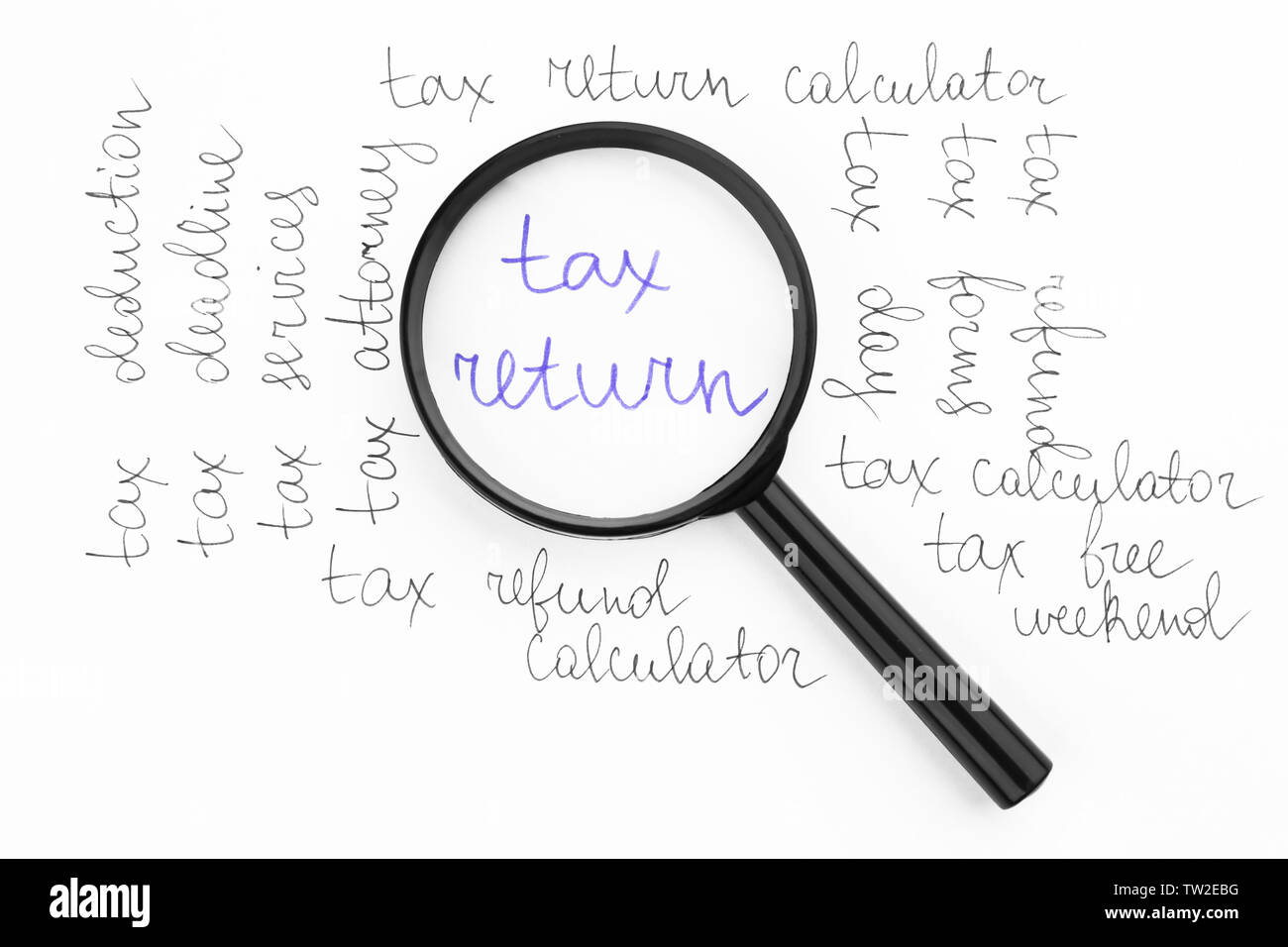 TAX RETURN text written on paper and hand glass Stock Photo - Alamy