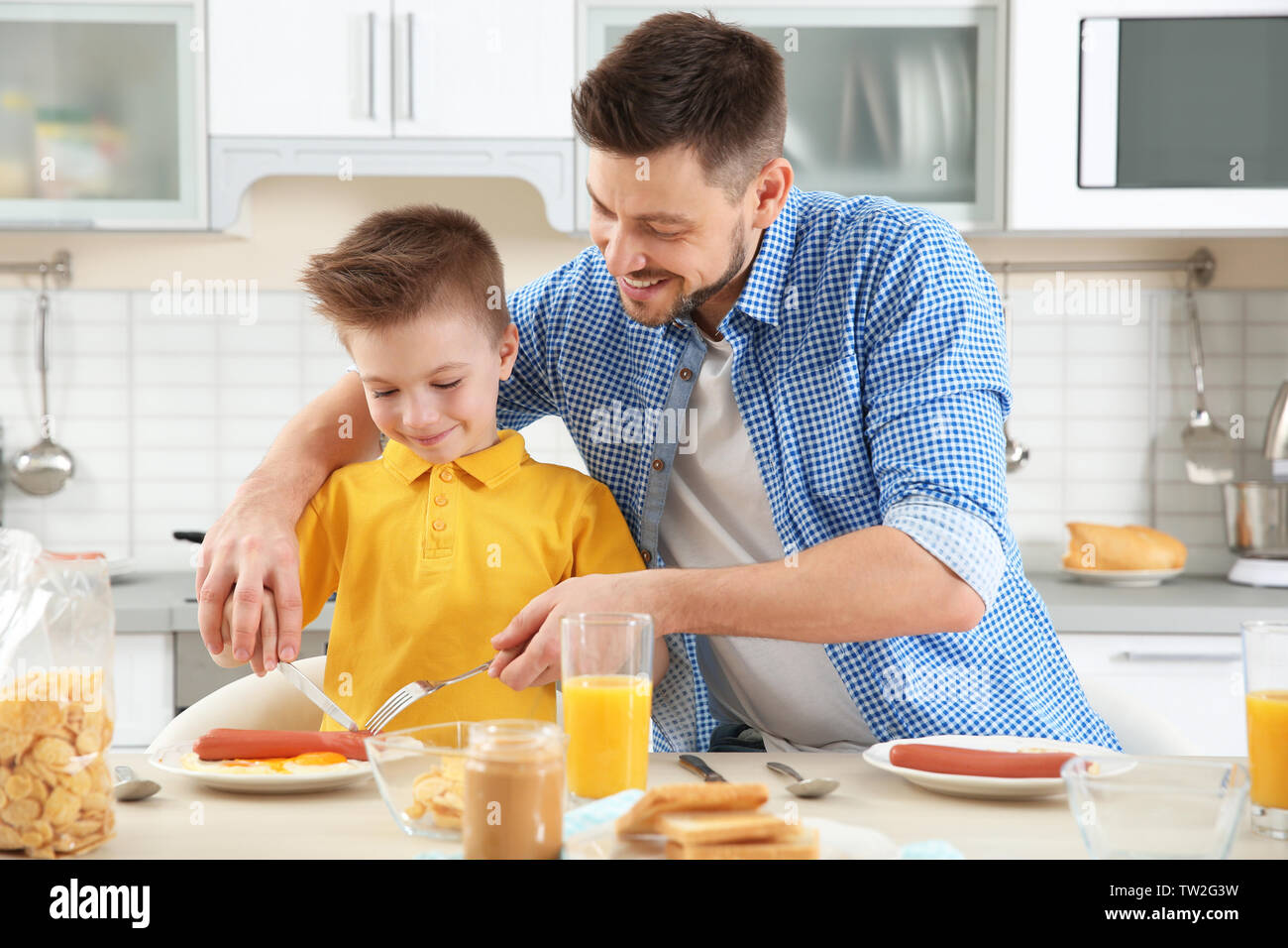 Dad and son having lunch at home Stock Photo - Alamy