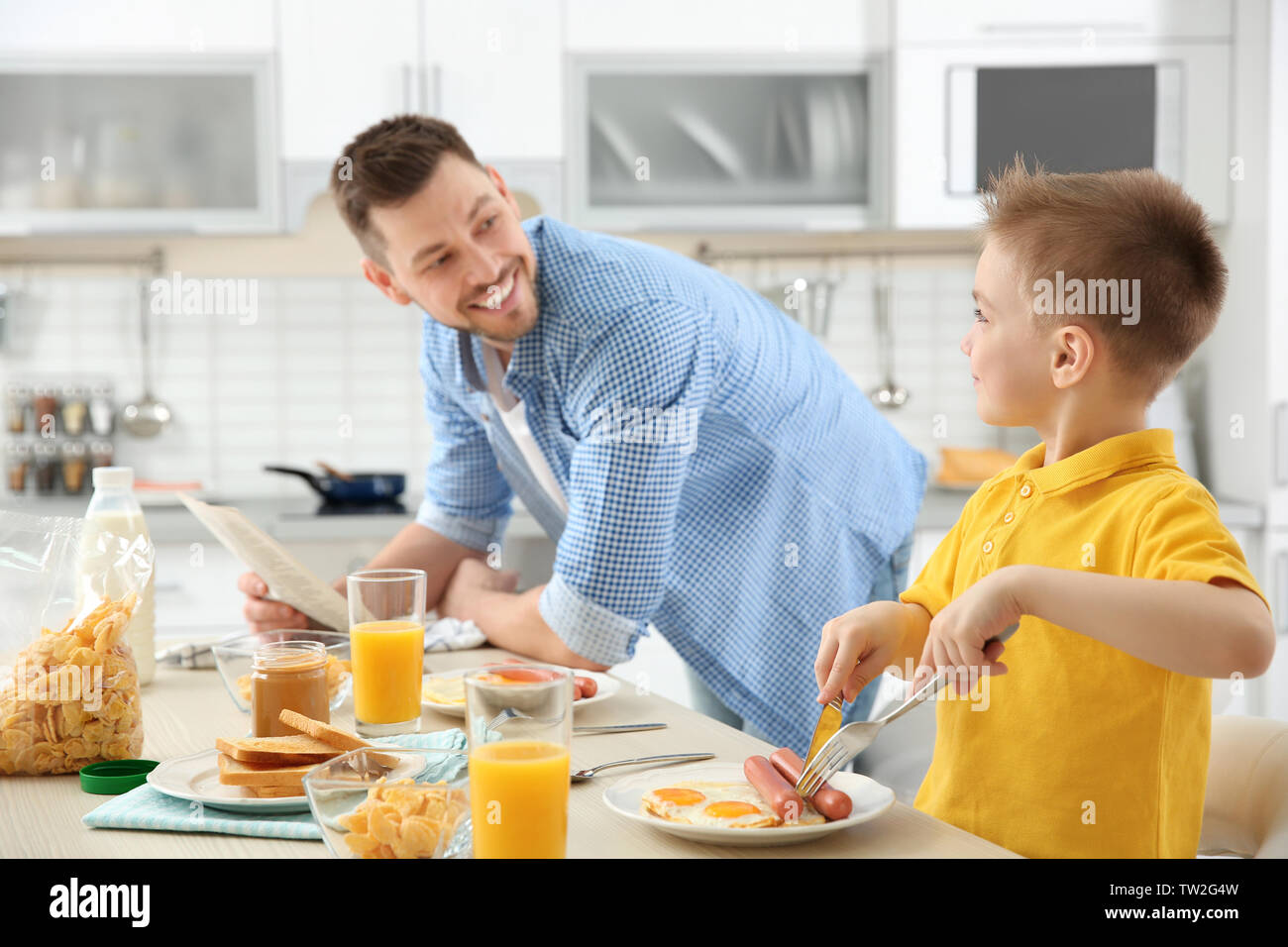 Dad and son having lunch at home Stock Photo - Alamy