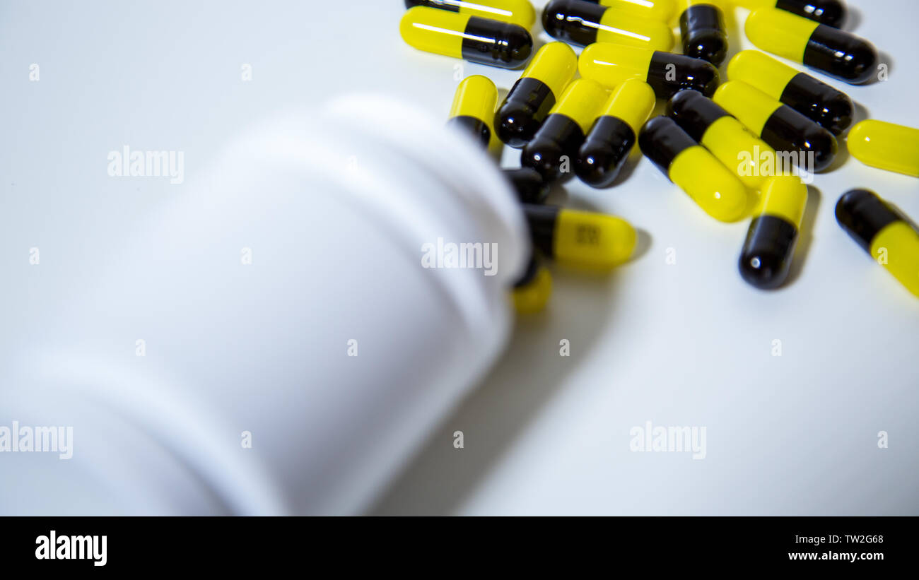Close up on a bottle of prescription drugs falling out. Black and ...