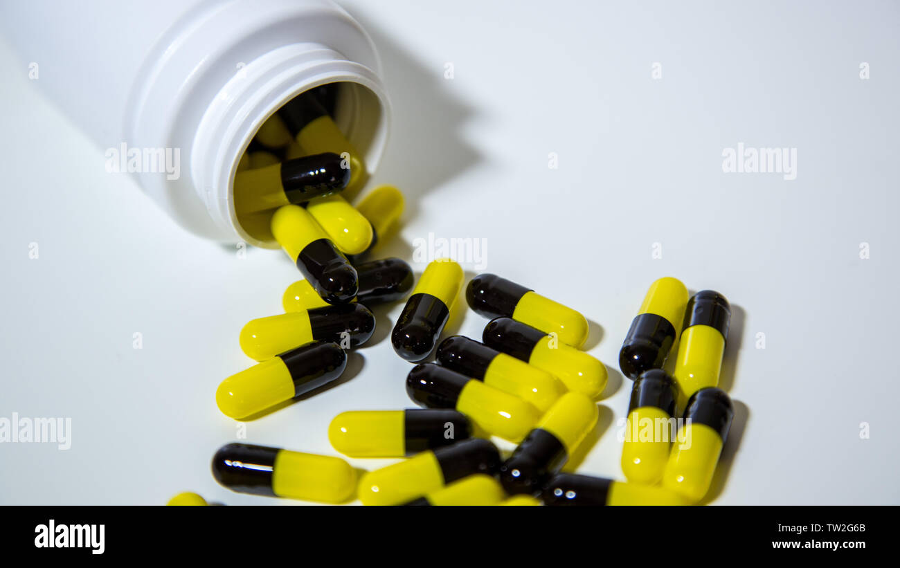 Close up on a bottle of prescription drugs falling out. Black and ...