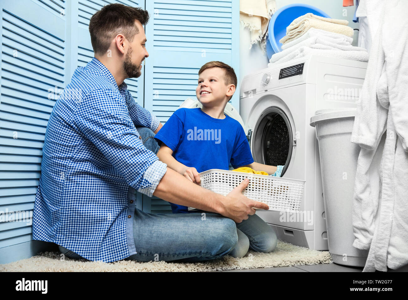 Dad and son doing laundry at home Stock Photo - Alamy