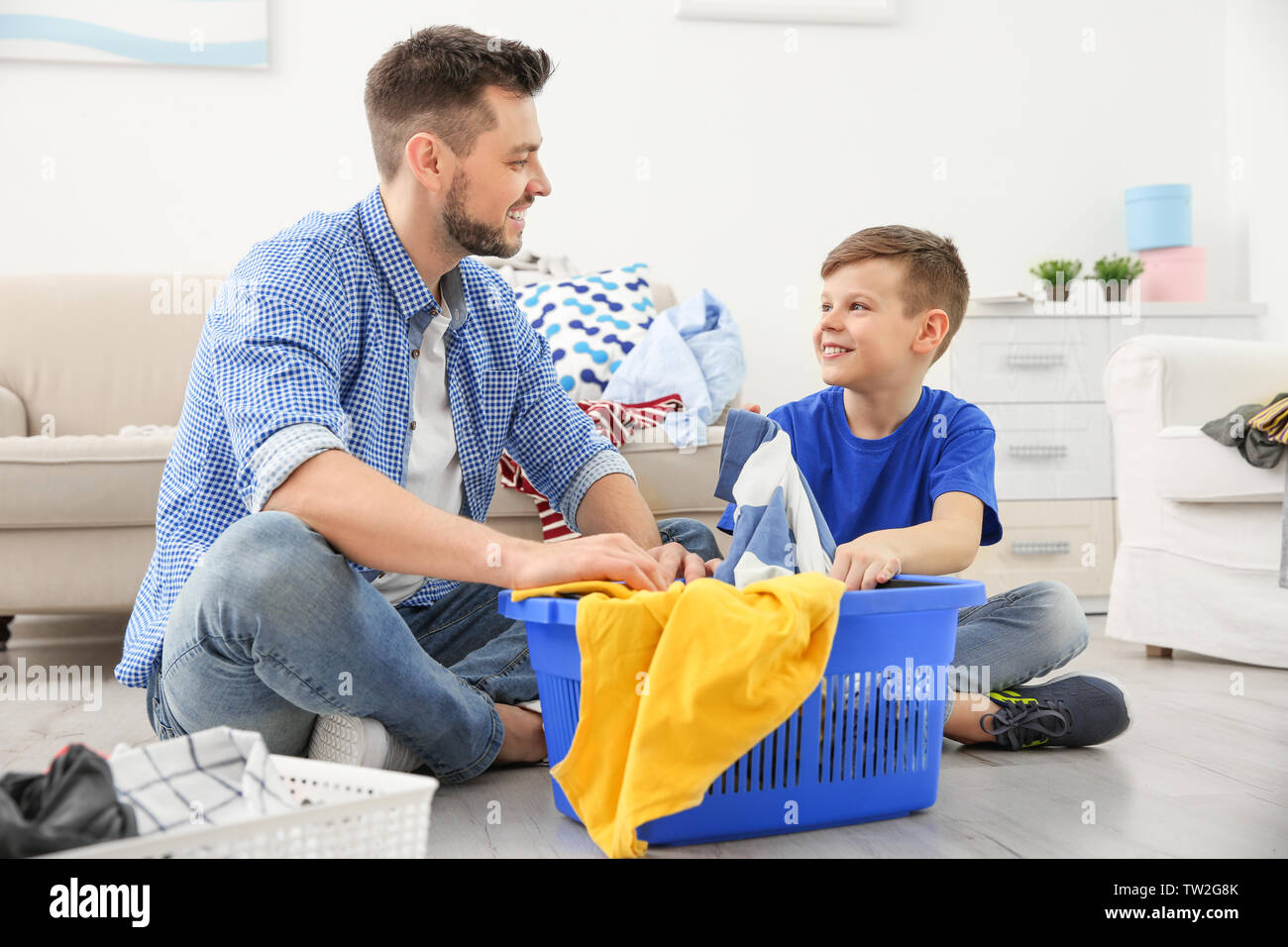 Dad and son preparing clothes for laundry at home Stock Photo - Alamy