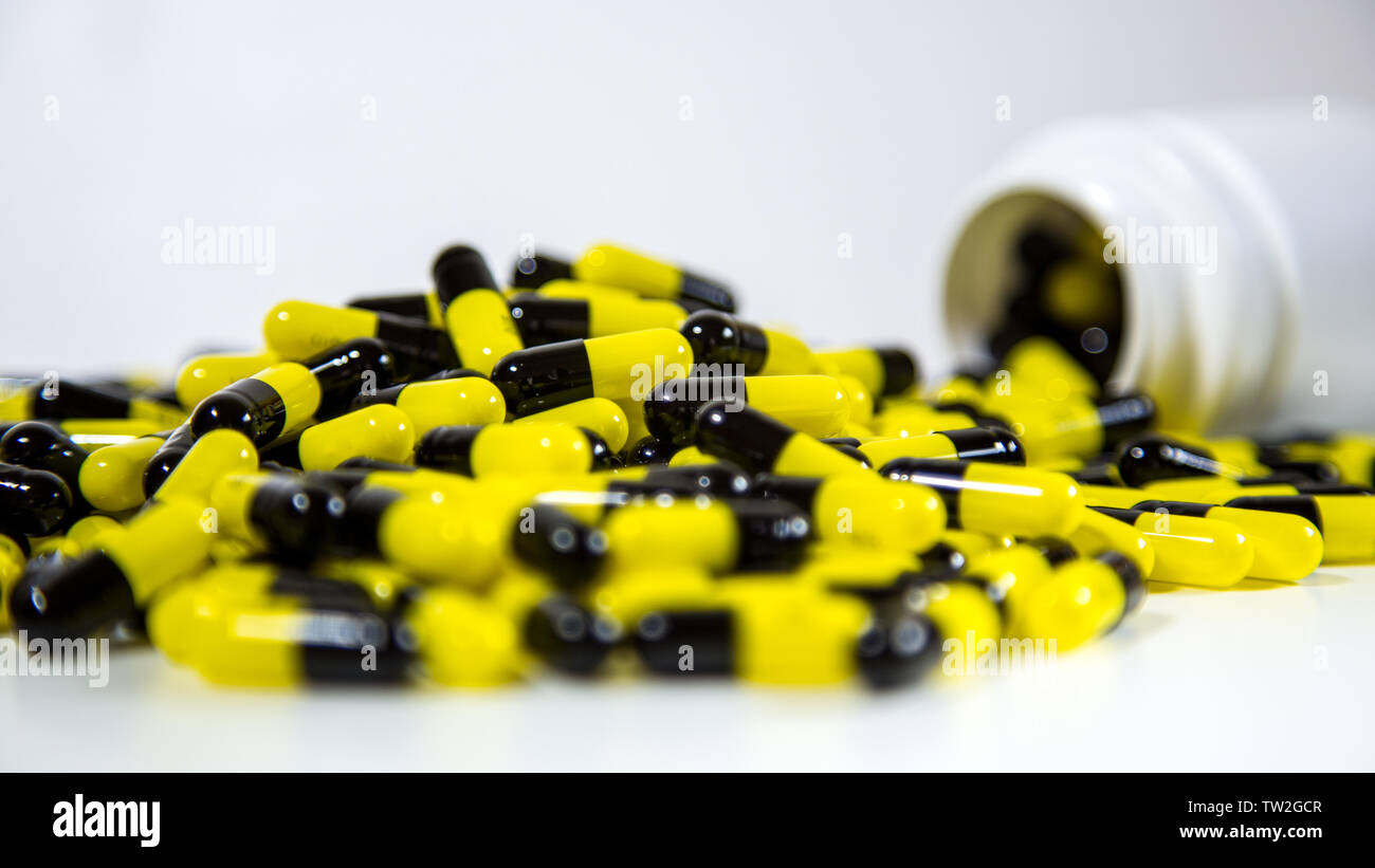 Close up on a bottle of prescription drugs falling out. Black and ...