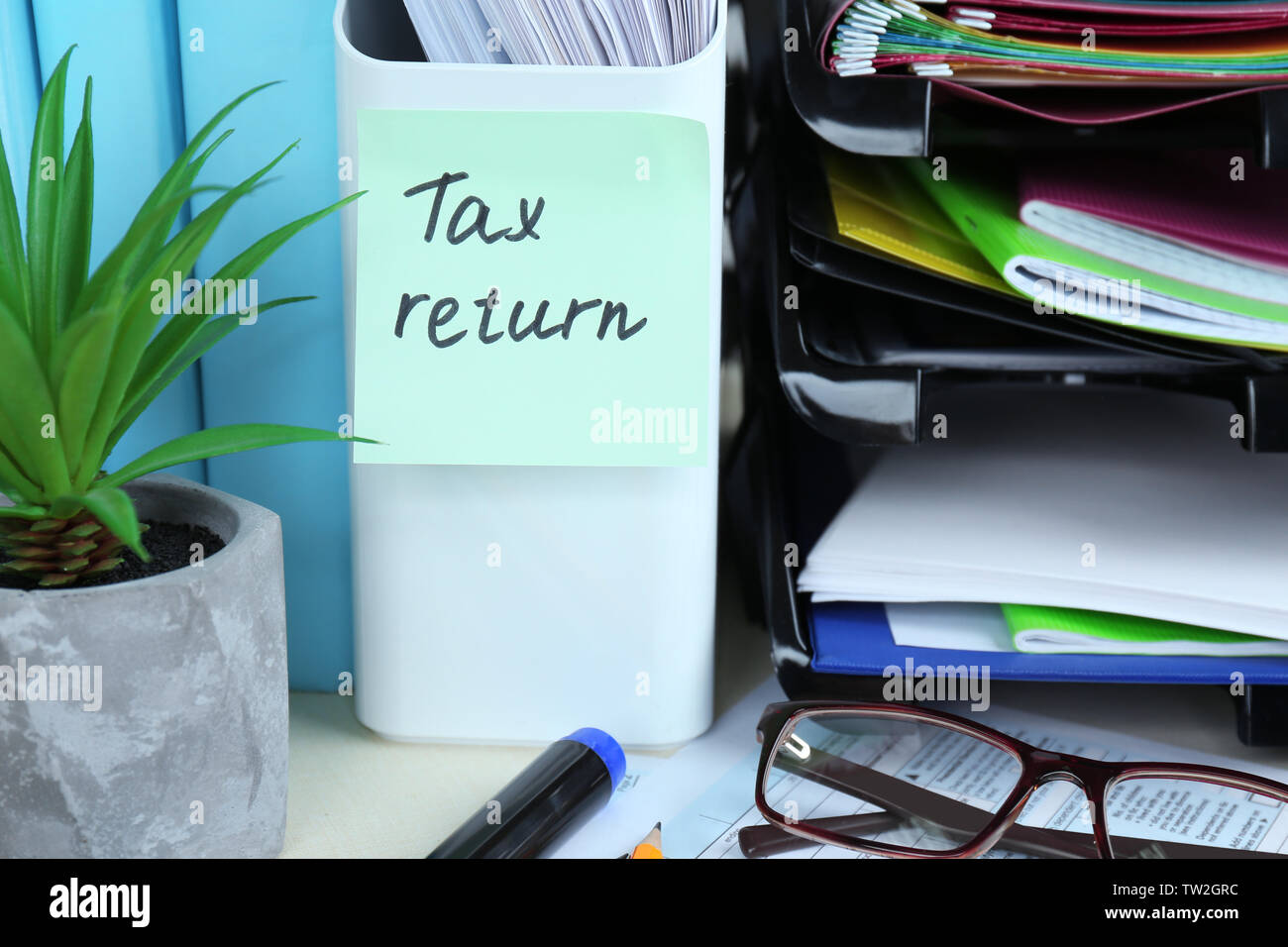 Note with TAX RETURN text and stationery on table Stock Photo - Alamy