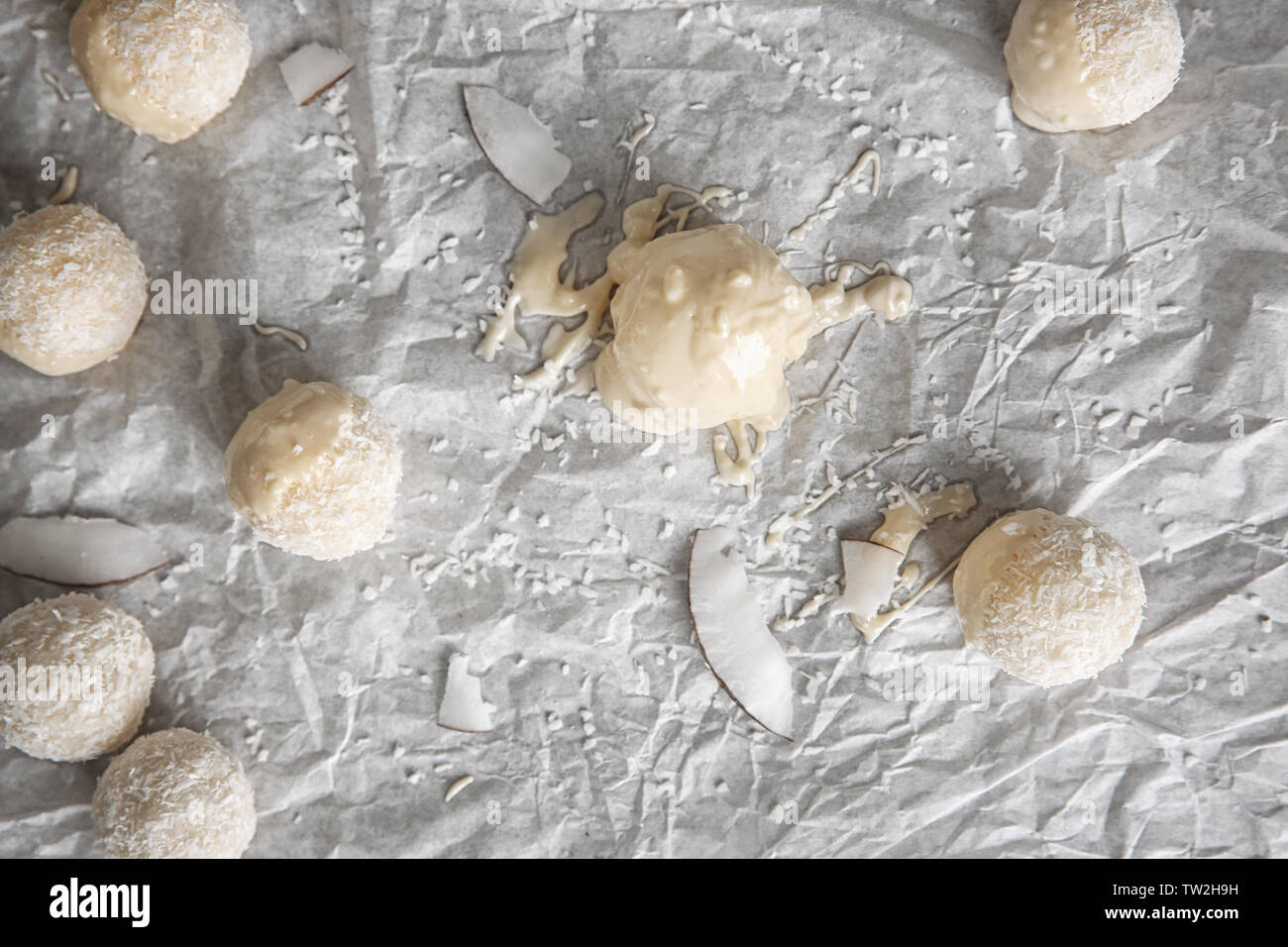 Tasty candies in coconut flakes on parchment paper Stock Photo - Alamy