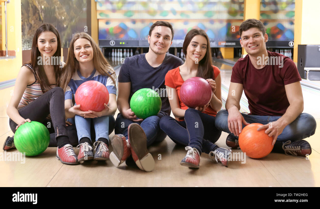 Friends sitting on floor in bowling club Stock Photo - Alamy