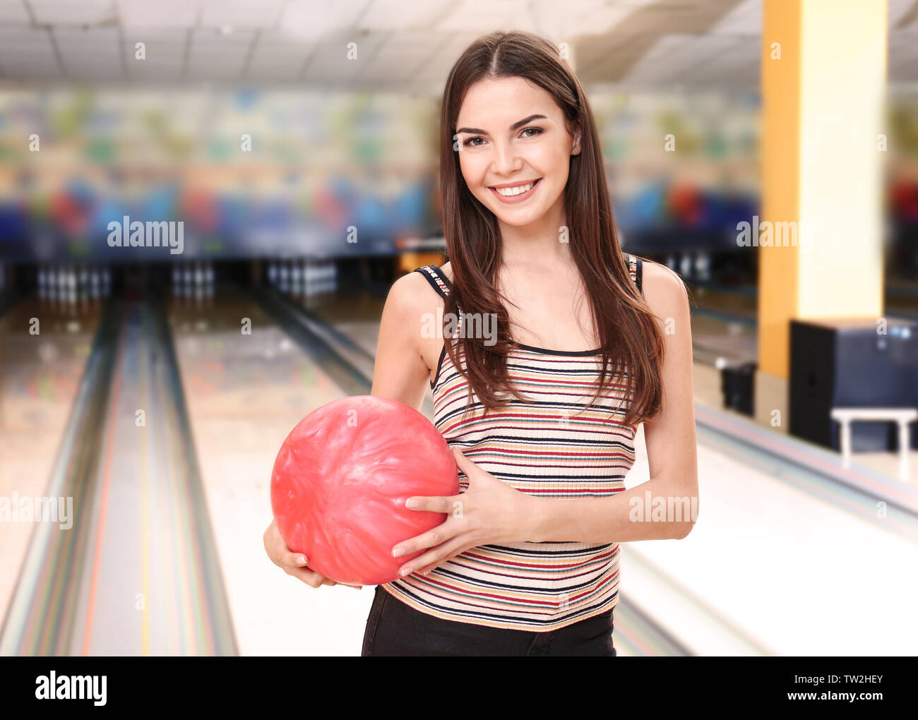 Beautiful young woman with ball in bowling club Stock Photo - Alamy