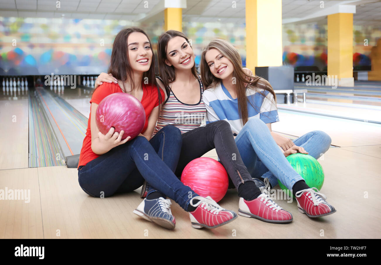Friends sitting on floor in bowling club Stock Photo - Alamy
