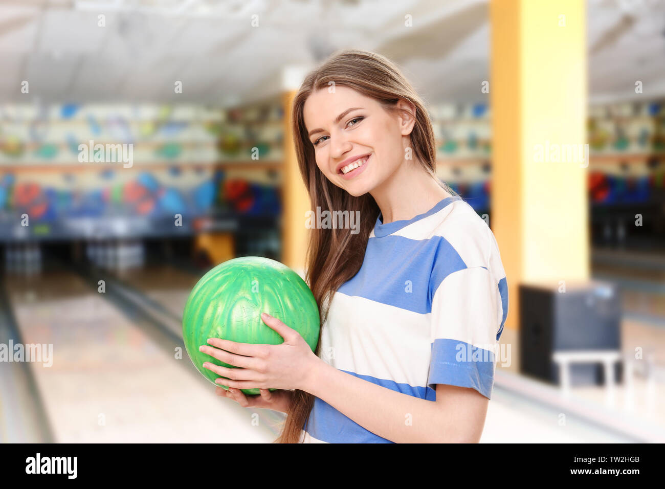 Beautiful young woman with ball in bowling club Stock Photo - Alamy