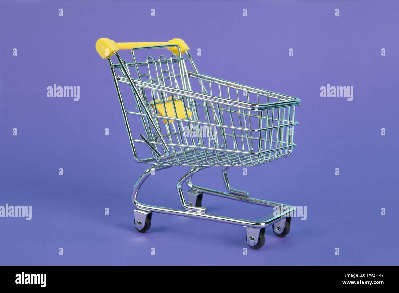 a mini cart on a purple background with a play of coloured light ...