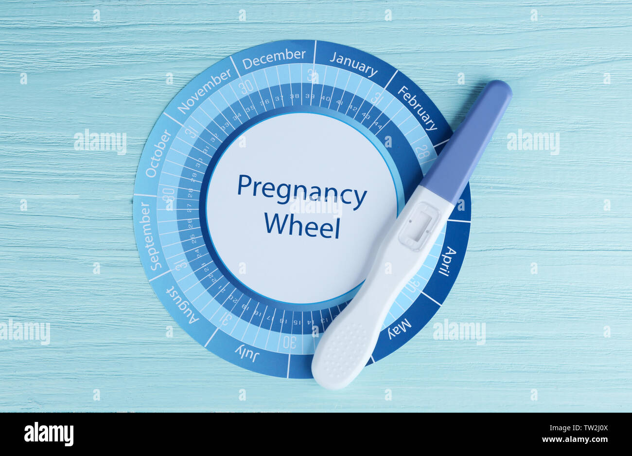 Pregnancy wheel calendar and test on blue table Stock Photo - Alamy