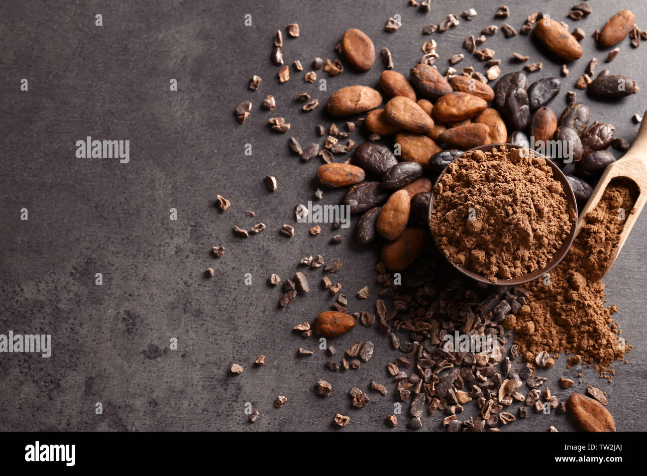Bowl and wooden scoop with aromatic cocoa powder on gray background ...