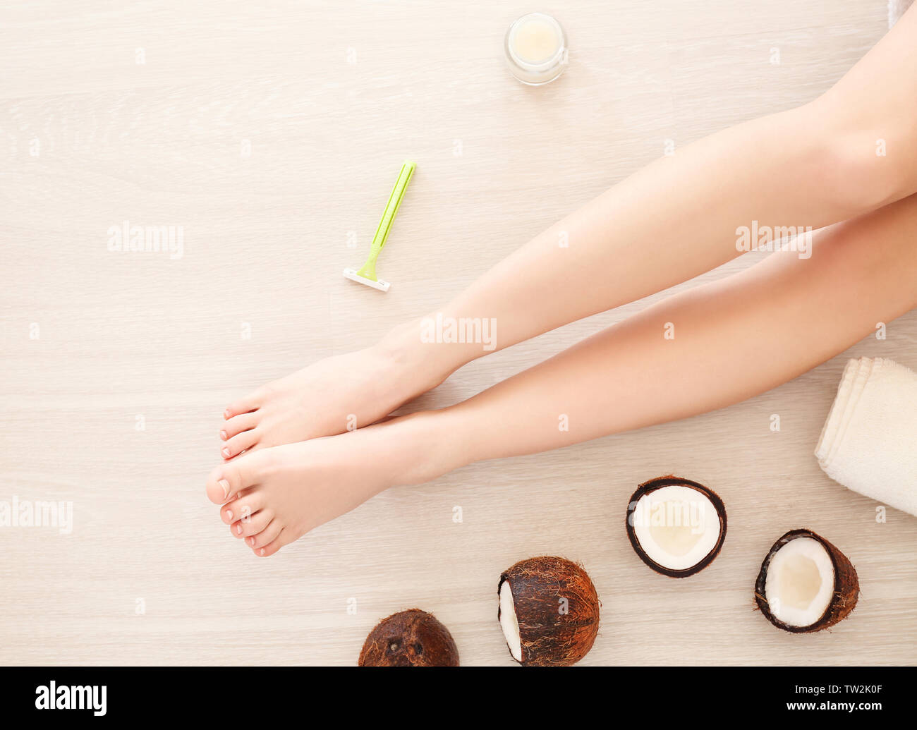 Coconut oil for skin concept. Female legs, coconut oil and fresh nuts ...