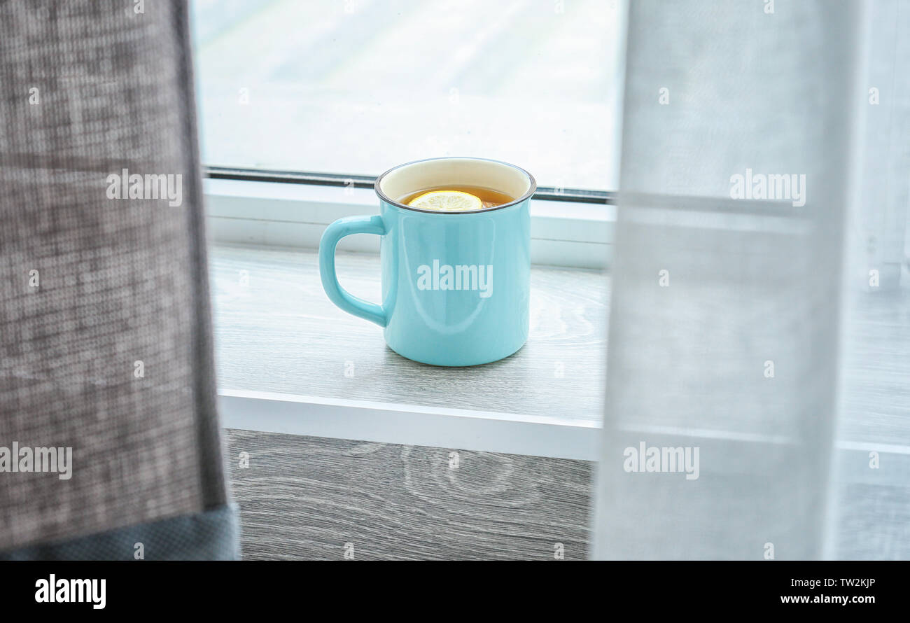 Cup of hot tea with lemon on window sill Stock Photo - Alamy