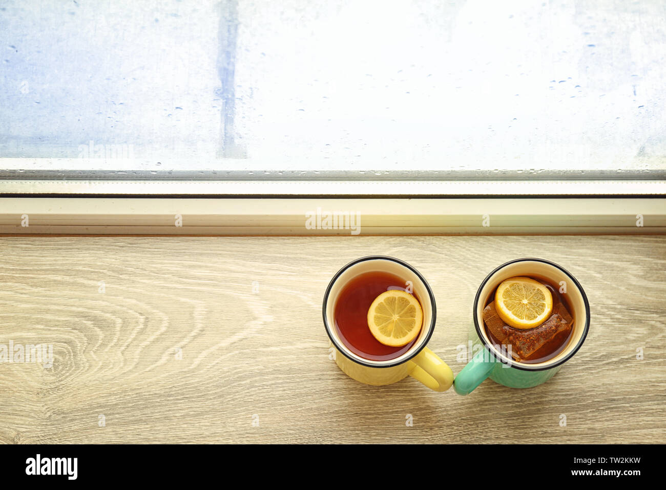 Cups of hot tea with lemon on window sill Stock Photo - Alamy