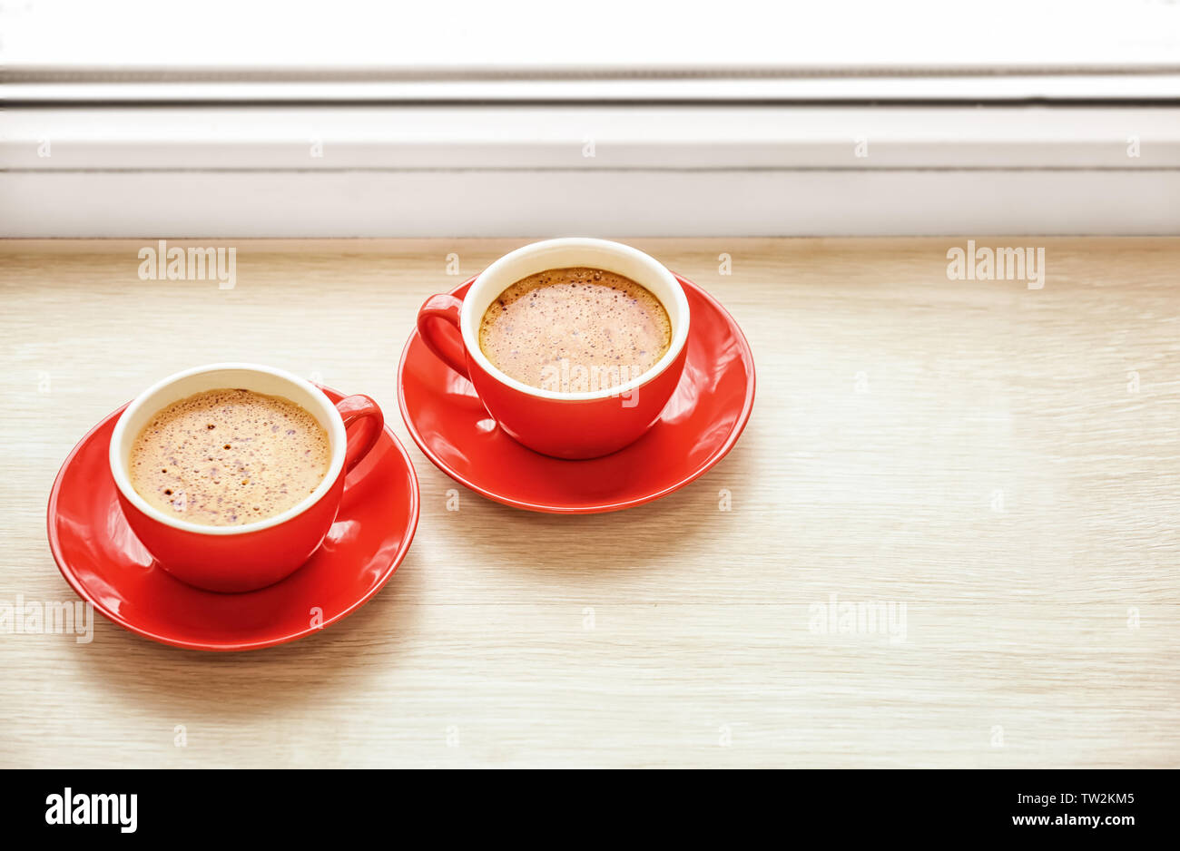 Cups with hot coffee on window sill Stock Photo - Alamy