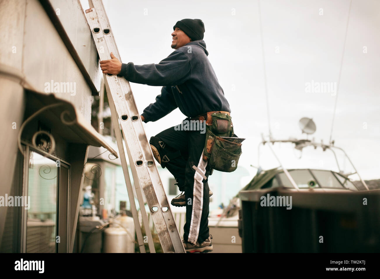 Builder climbing ladder Stock Photo - Alamy