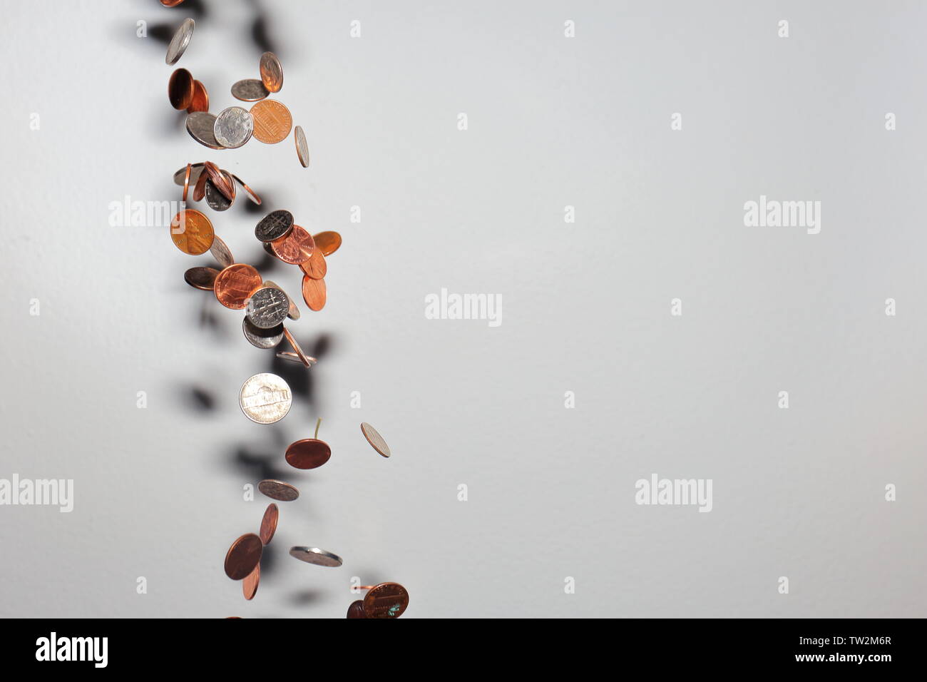 Falling US coins isolated to the left side of the image in front of a ...